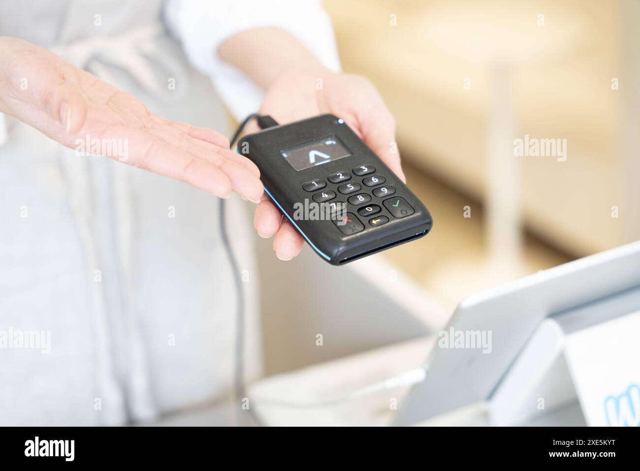 Woman holding an electronic payment terminal Stock Photo - Alamy