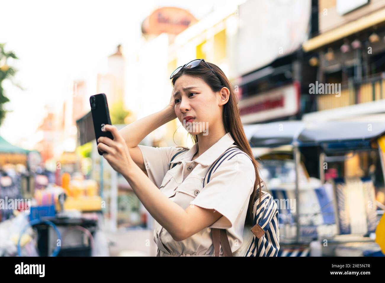 Young Asian woman getting lost and using map on a mobile phone while ...