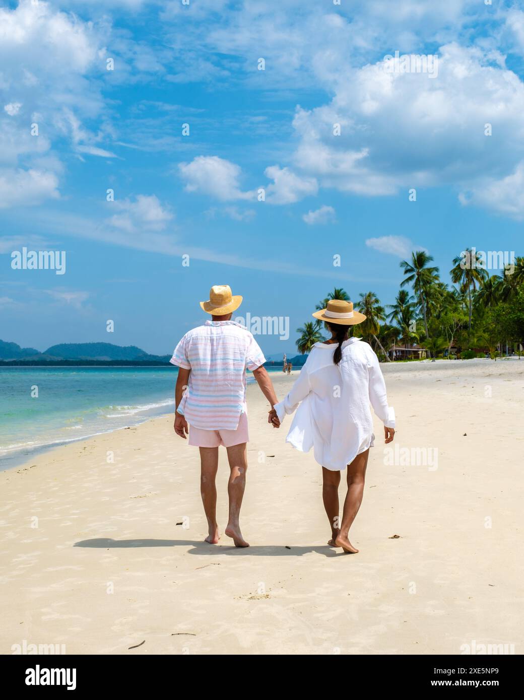 Koh Mook a young couple of caucasian men and Thai Asian woman walking ...