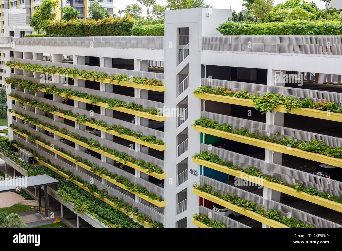 Multistorey carpark planted with green plants on the ledges. Trees on ...
