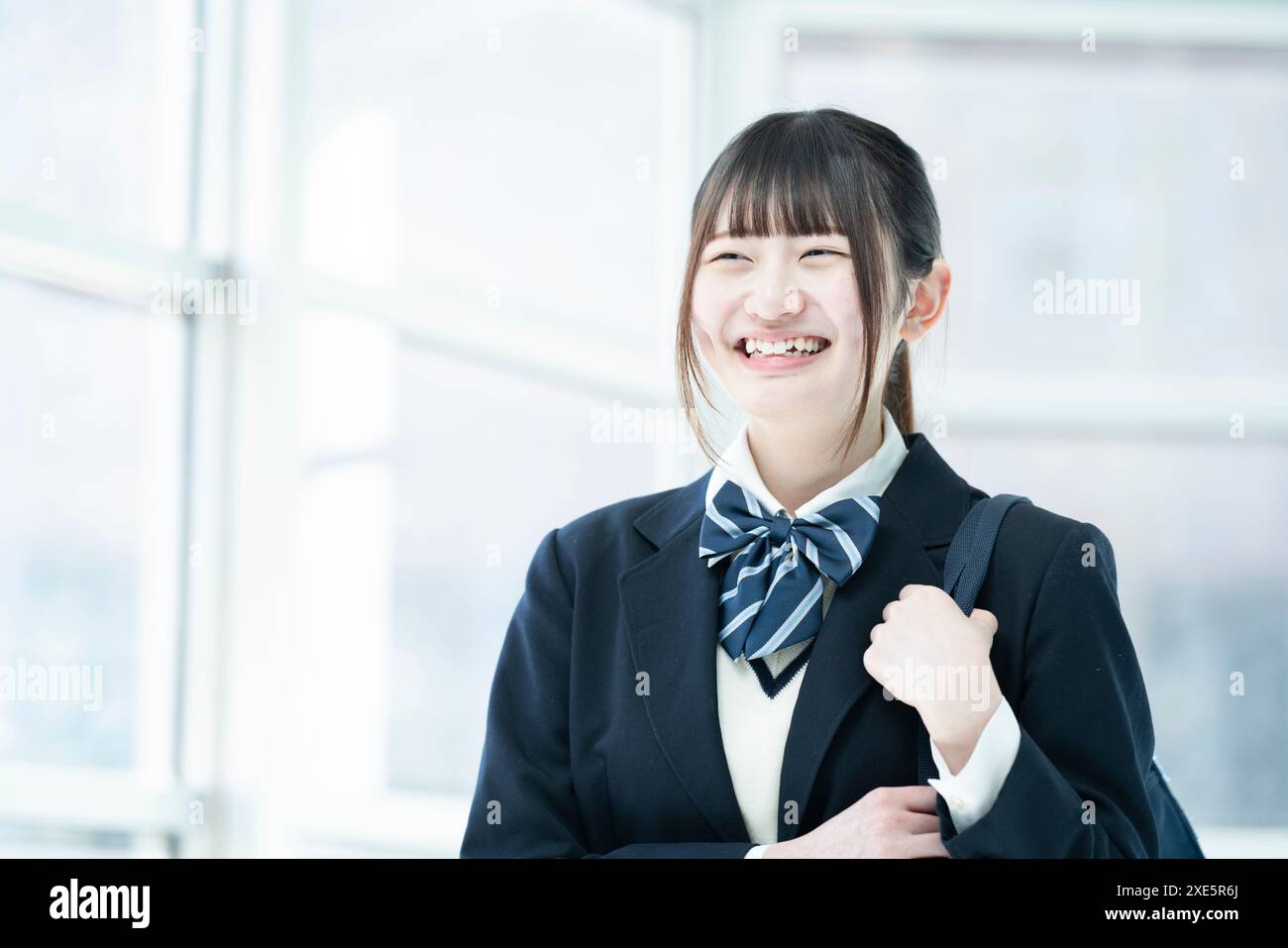 Female student in uniform laughing indoors Stock Photo - Alamy