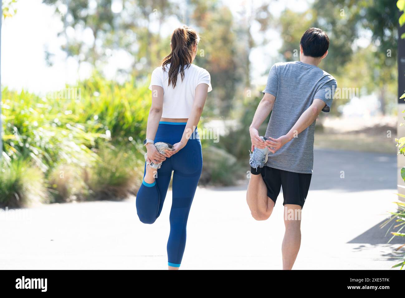 Back view of man and woman stretching Stock Photo - Alamy