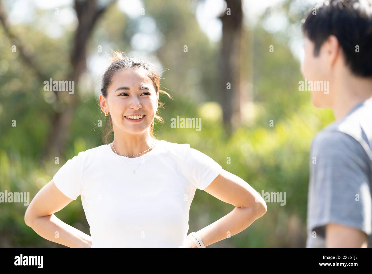 Male/female couple laughing while stretching in park Stock Photo - Alamy