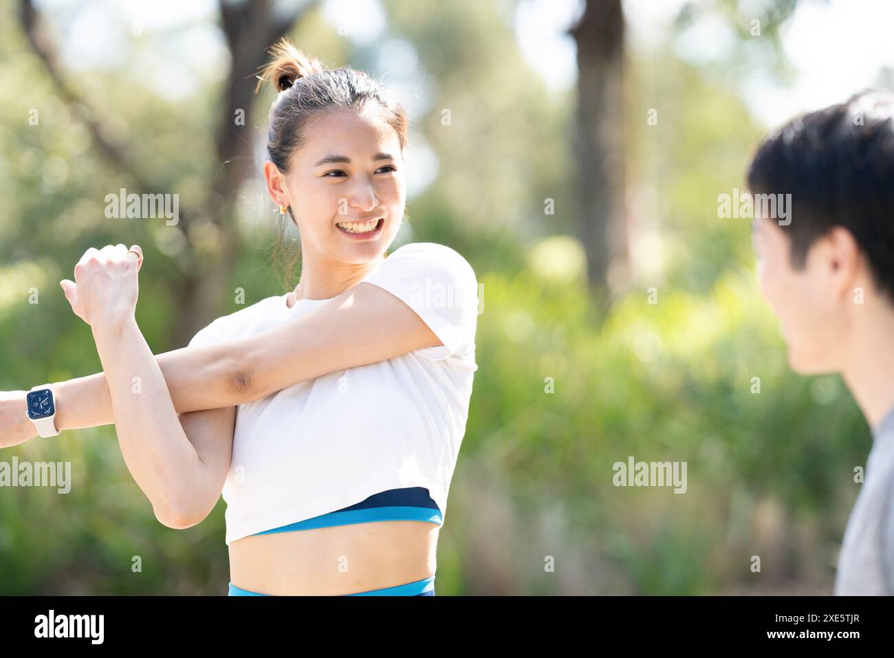 Male/female couple laughing while stretching in park Stock Photo - Alamy