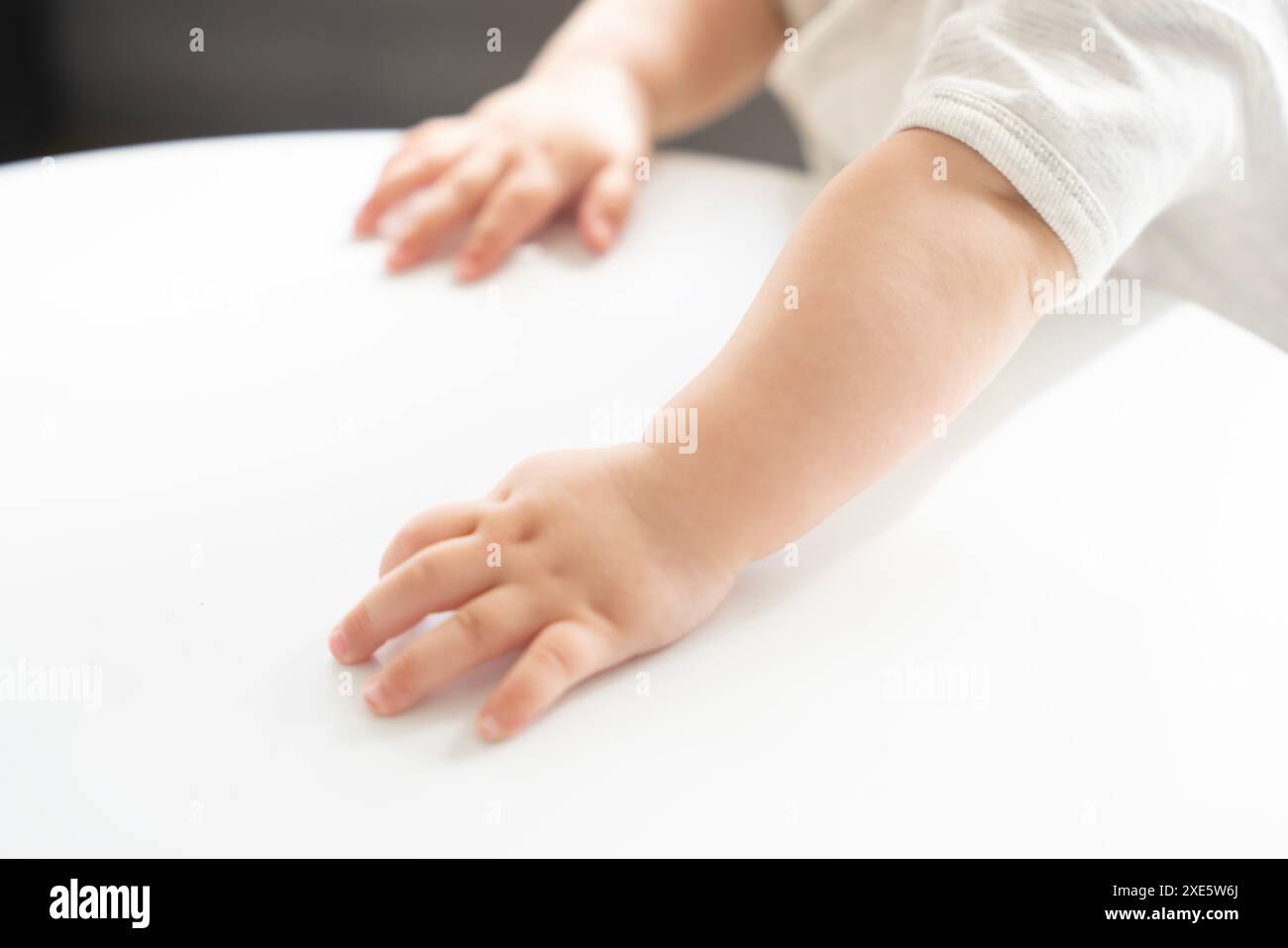 Baby's hand touching table top Stock Photo - Alamy