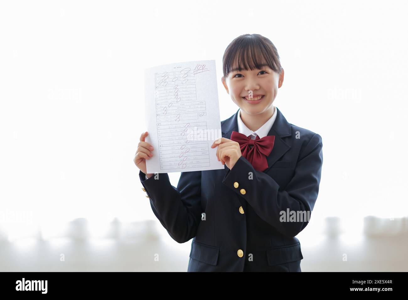 Girl holding test with perfect score Stock Photo - Alamy