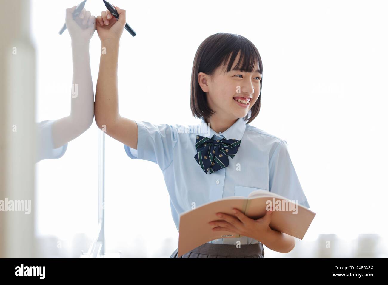 Student writing answers on whiteboard Stock Photo - Alamy