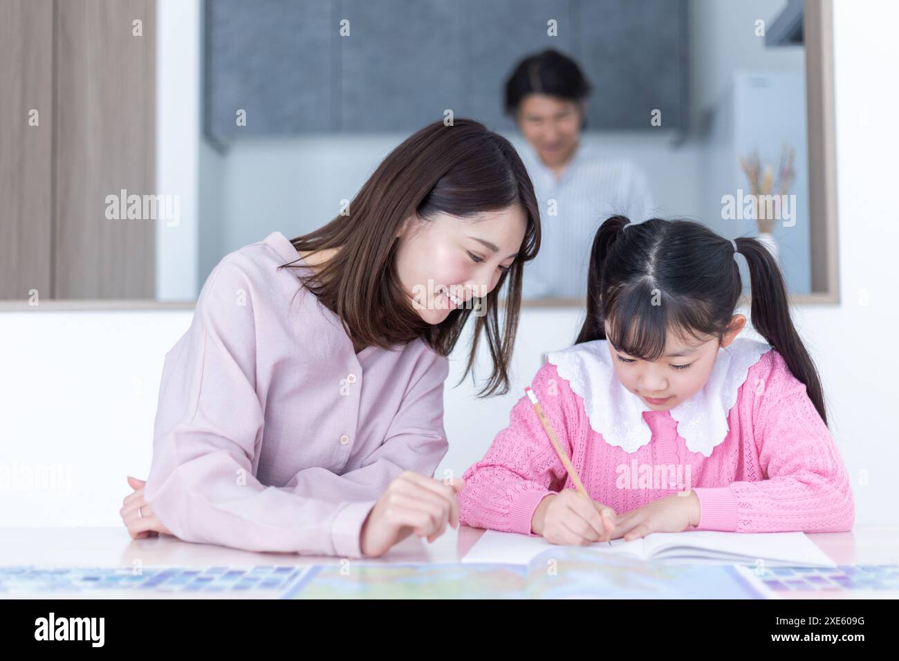 Child studying and mother teaching Stock Photo - Alamy