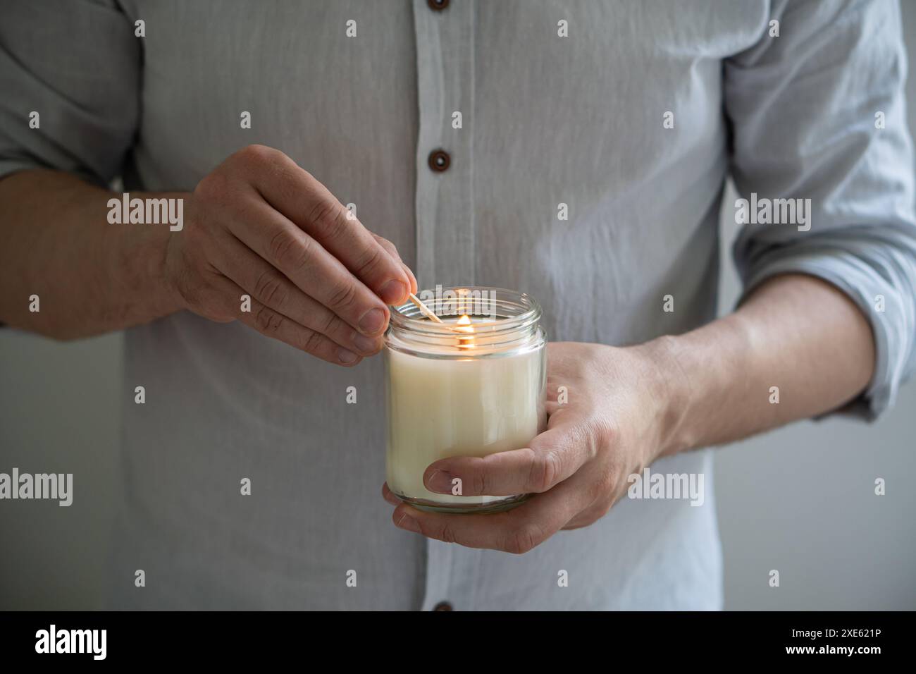 Man holding a burning candle in his hands, elegant young man with ...