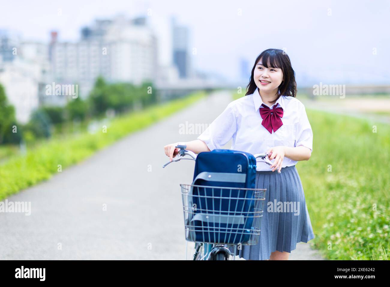 High school girl pushing a bicycle Stock Photo - Alamy