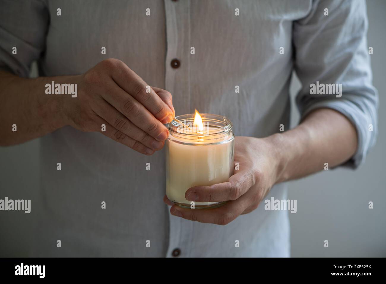Man holding a burning candle in his hands, elegant young man with ...