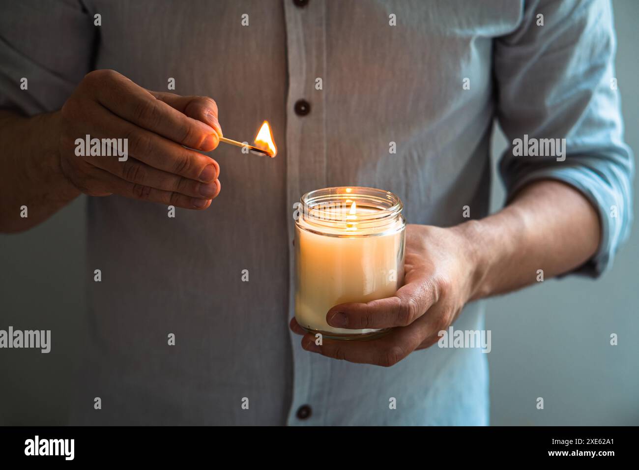 Man holding a burning candle in his hands, elegant young man with ...