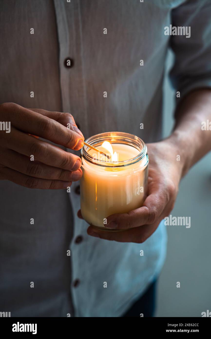 Man holding a burning candle in his hands, elegant young man with ...