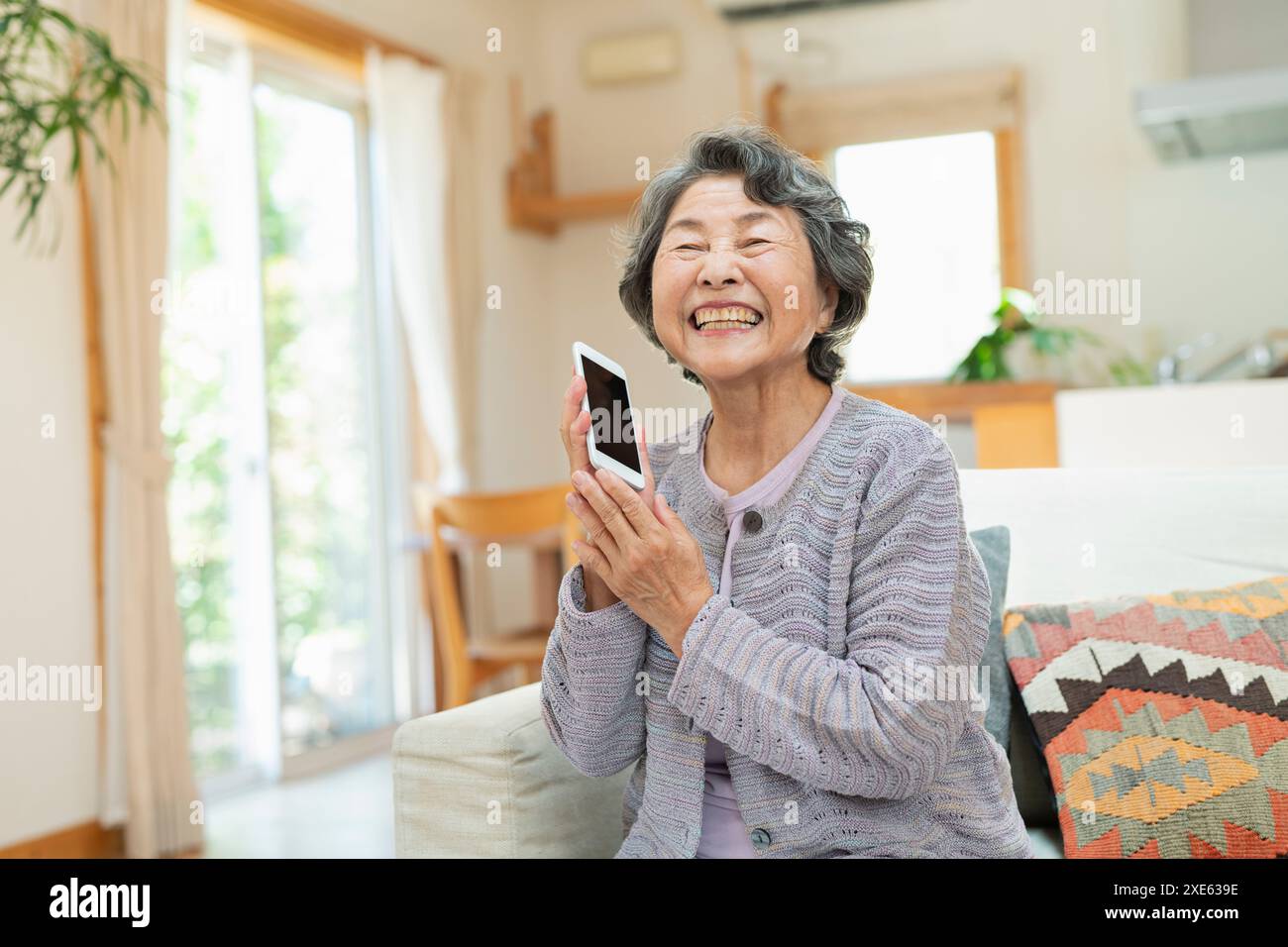 Senior woman making a phone call at home Stock Photo - Alamy