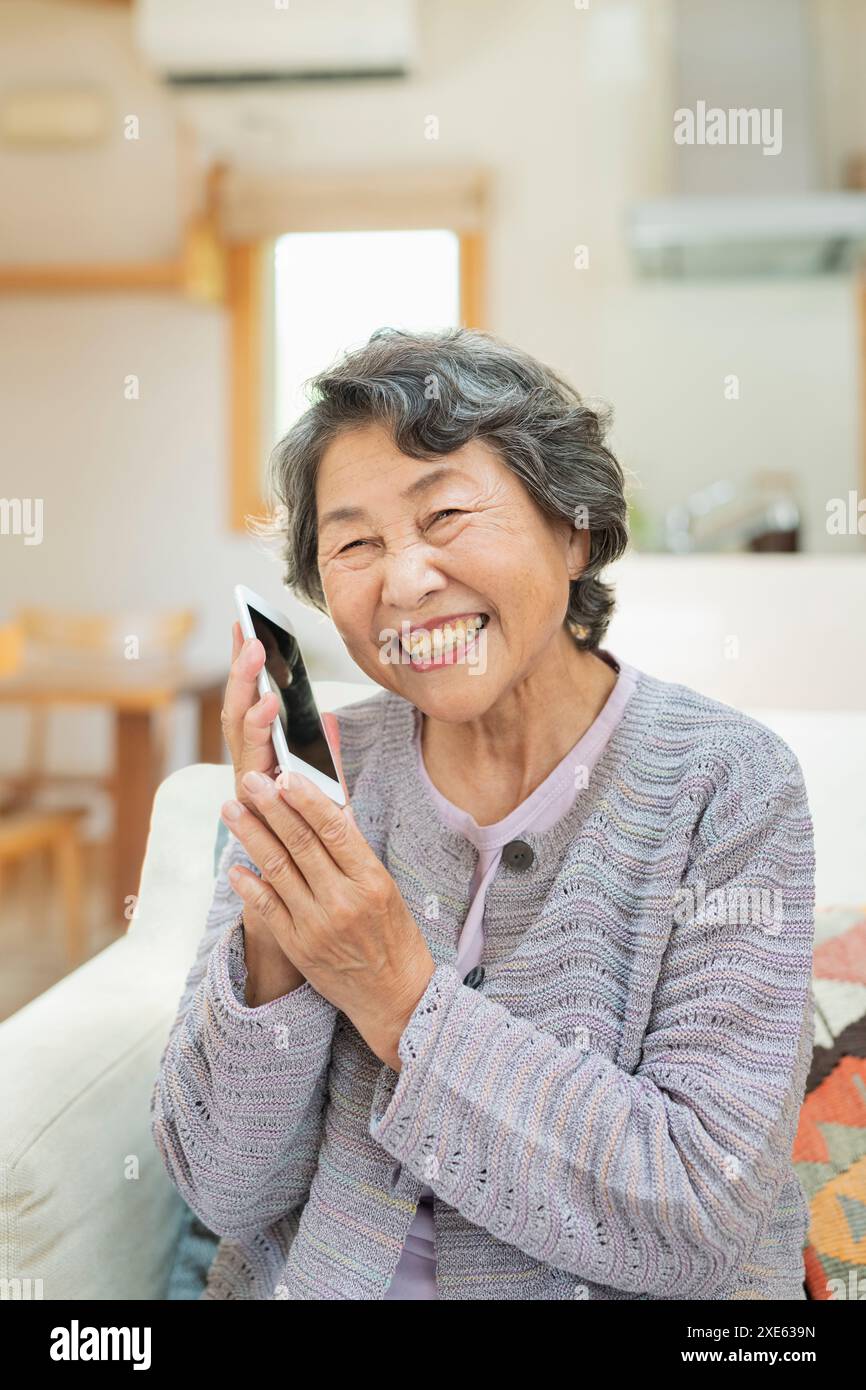 Senior woman making a phone call at home Stock Photo - Alamy