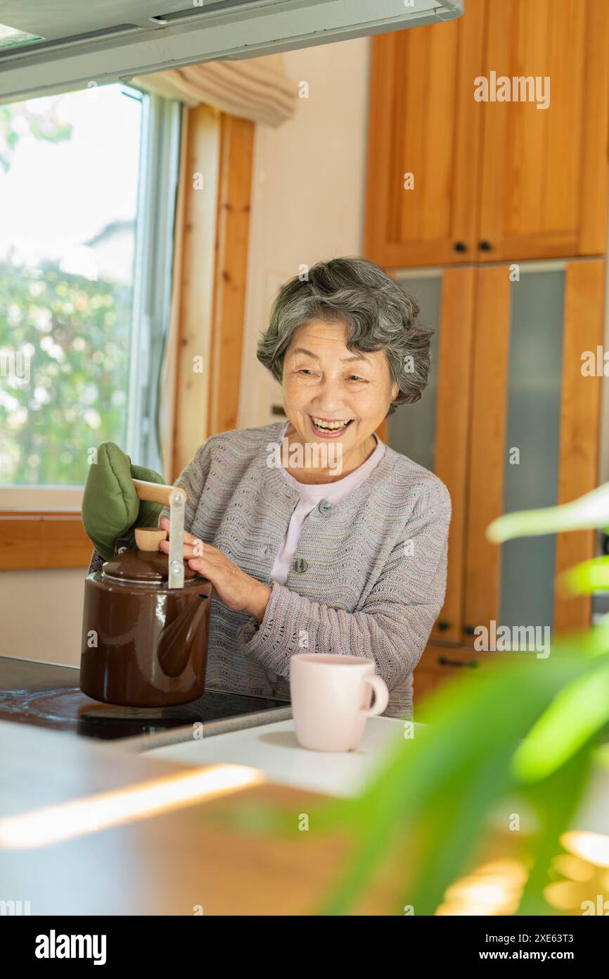 Senior woman making tea in kitchen Stock Photo - Alamy