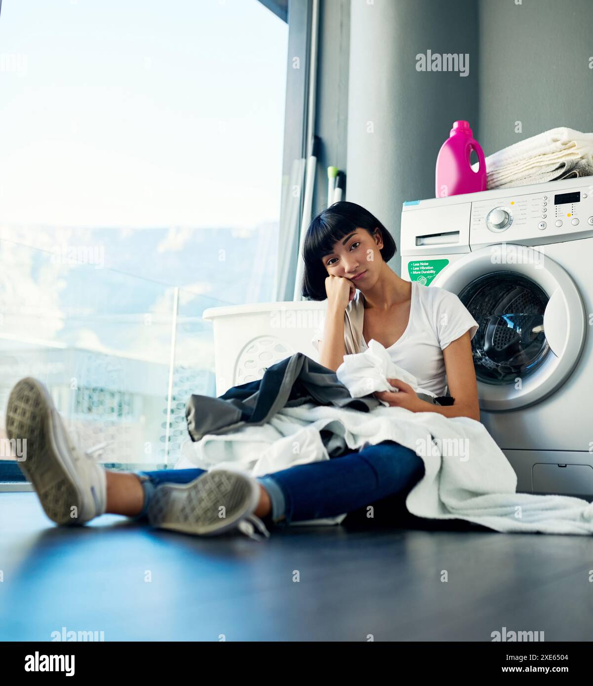 Washing machine, laundry and portrait of bored woman cleaning clothes ...