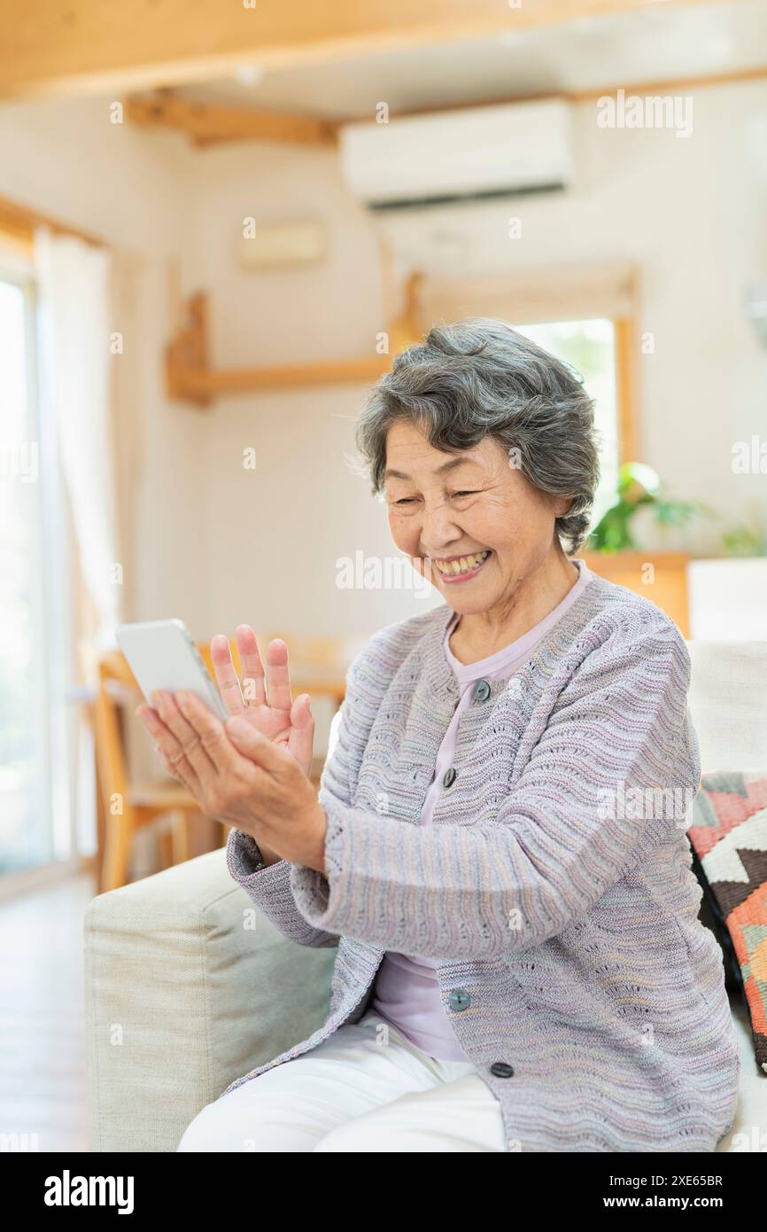 Senior woman making video calls with grandchildren at home Stock Photo ...