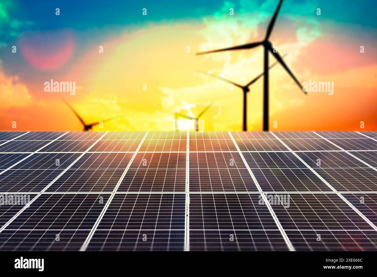 Solar panels on the background of a windmill at sunset. Photovoltaic ...