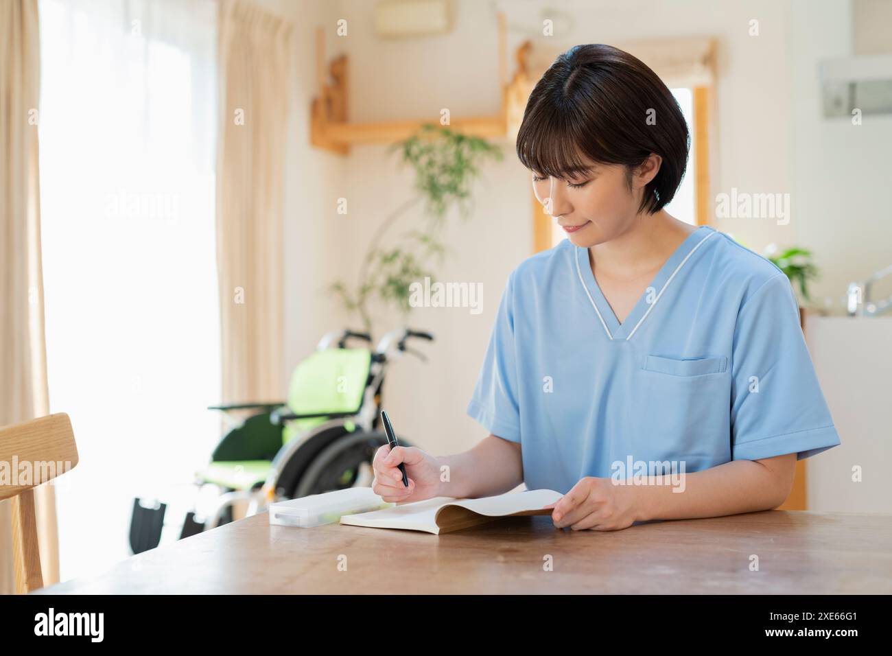 Female health care worker writing a diary Stock Photo - Alamy