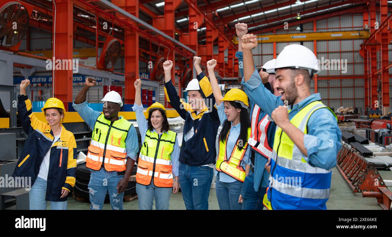 Group of factory workers in hardhats with arms raised celebrating success Stock Photo - Alamy
