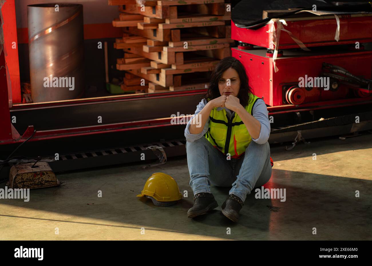 A young woman works in a warehouse storing rolls of metal sheet ...