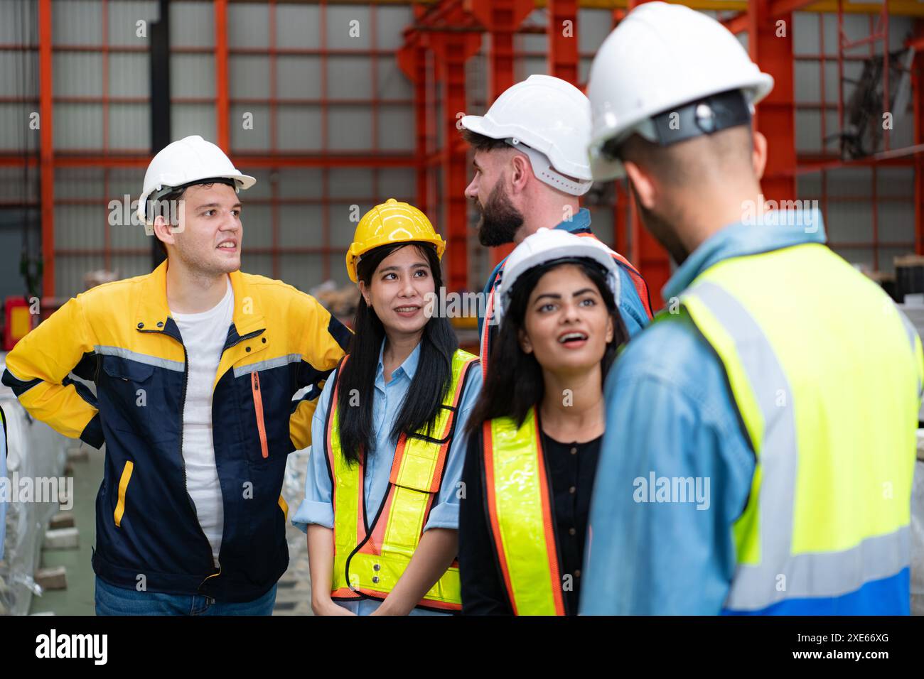 Group of factory workers in hardhats with joint hands together for ...