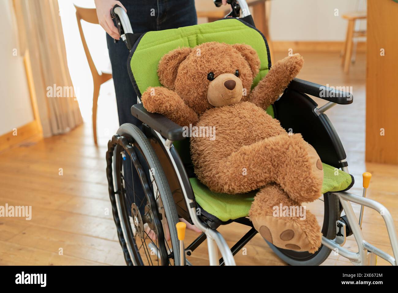 Living room, wheelchair, stuffed bear Stock Photo - Alamy