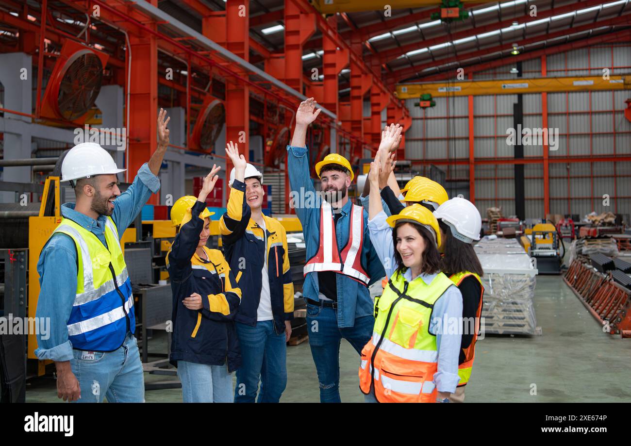 Group of factory workers in hardhats with arms raised celebrating success Stock Photo - Alamy