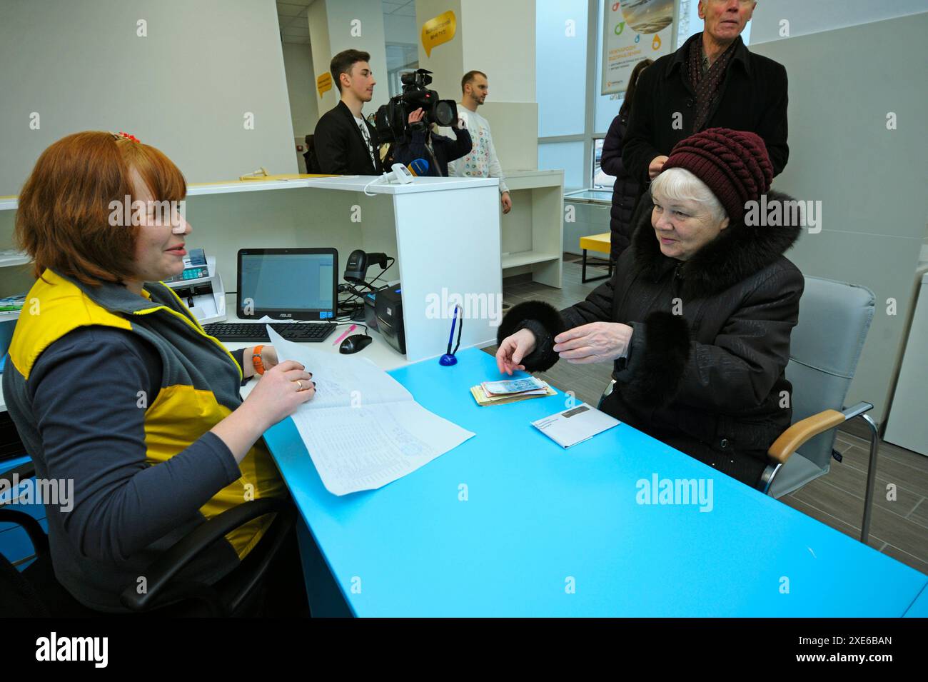 At the post office, workplace: postal worker in uniform giving pension ...