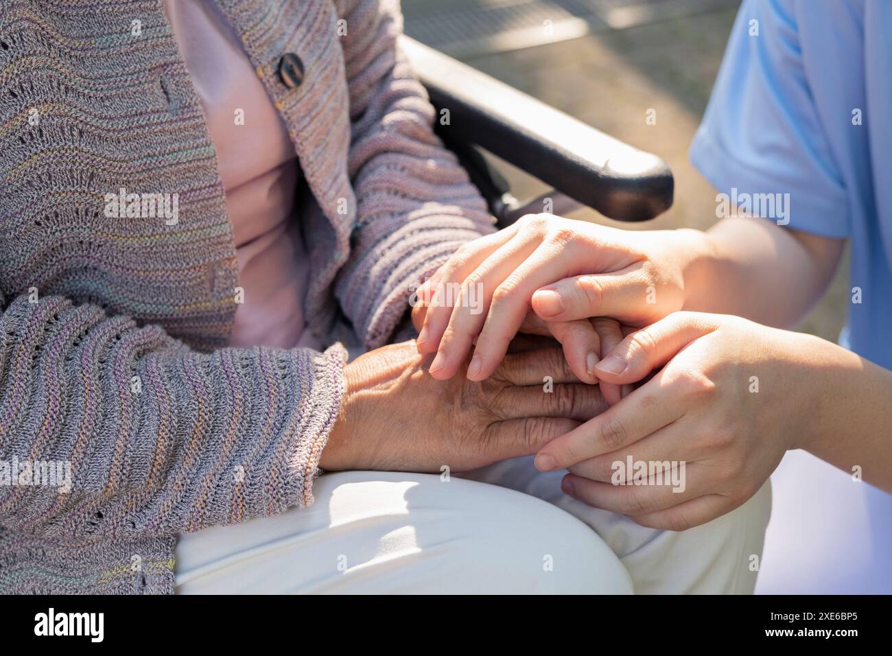 Caregiver holding senior woman's hand Stock Photo - Alamy