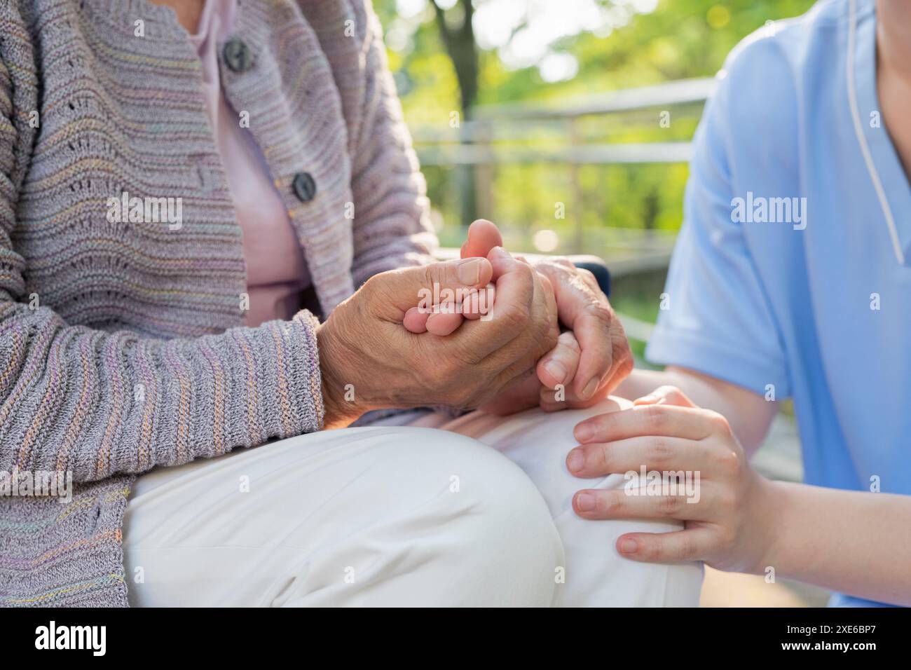 Caregiver holding senior woman's hand Stock Photo - Alamy
