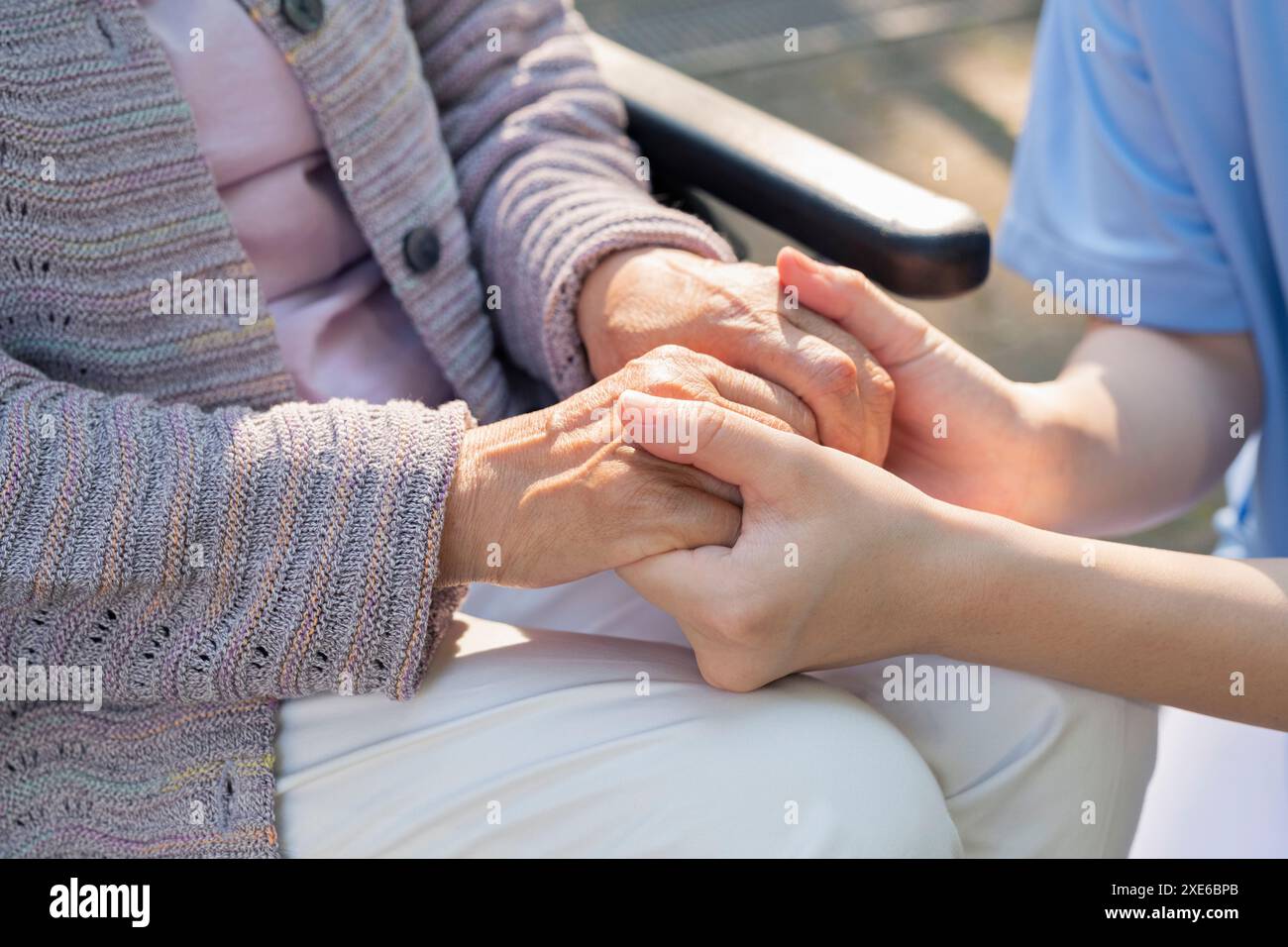 Caregiver holding senior woman's hand Stock Photo - Alamy