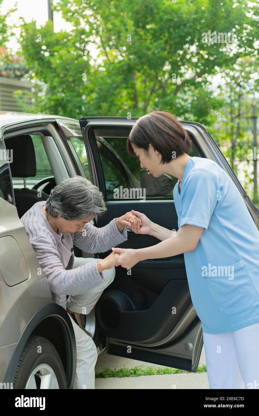 Female helper helping senior woman to get out of car Stock Photo - Alamy