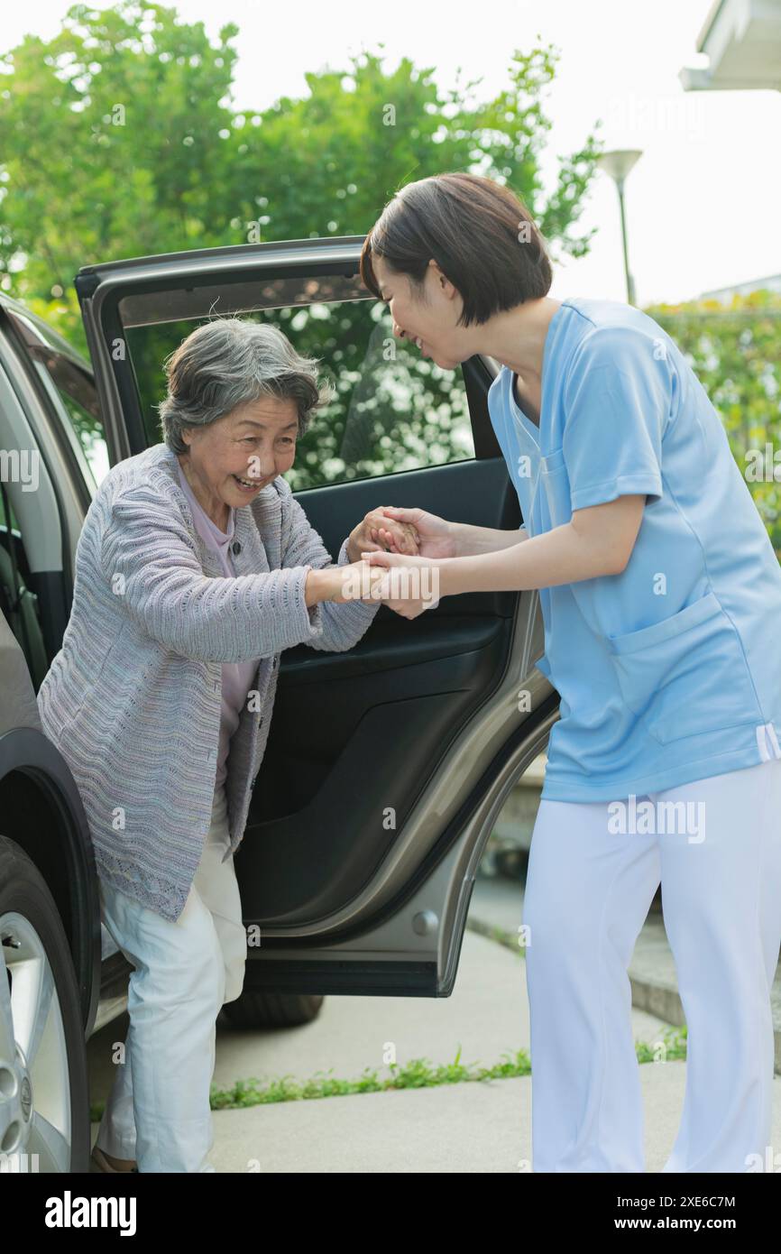 Female helper helping senior woman to get out of car Stock Photo - Alamy