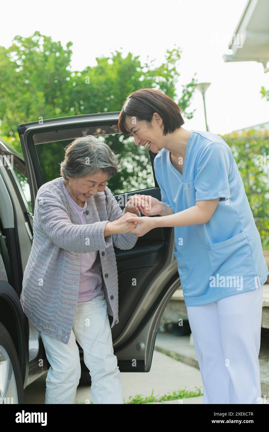 Female helper helping senior woman to get out of car Stock Photo - Alamy