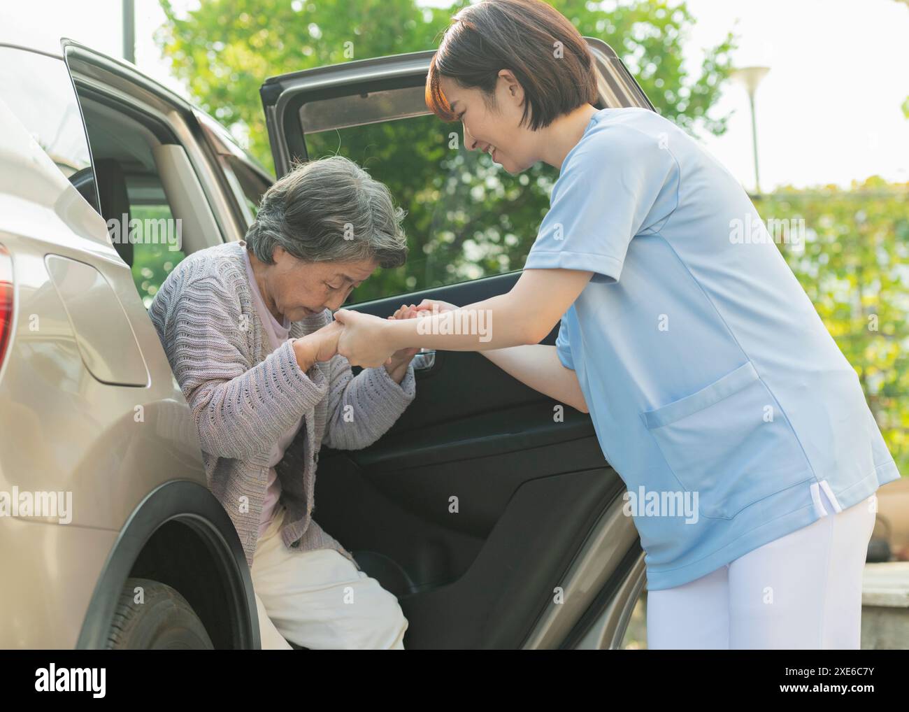 Female helper helping senior woman to get out of car Stock Photo - Alamy