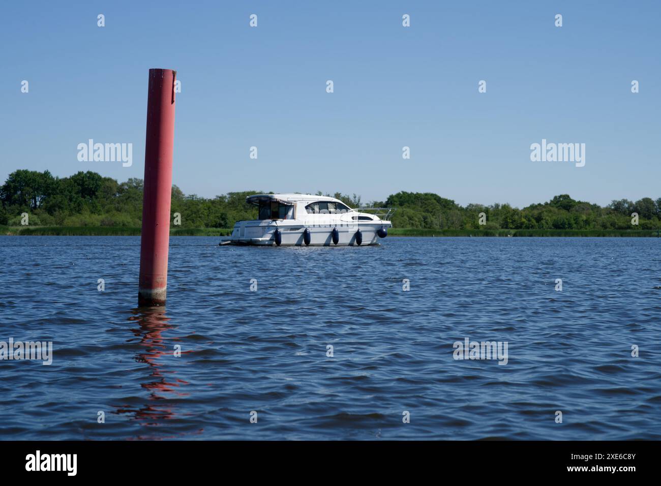 Motor cruiser passing a navigation channel marker post, Barton Broad ...