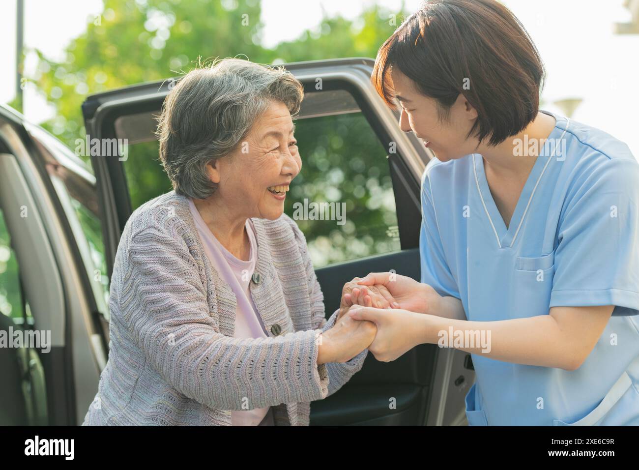 Female helper helping senior woman to get out of car Stock Photo - Alamy