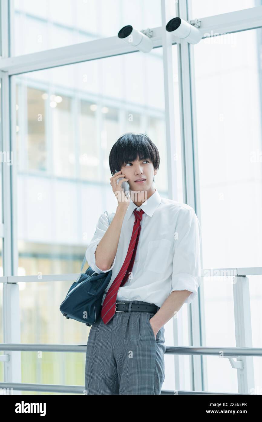 High school boy making a phone call on his way to school Stock Photo ...