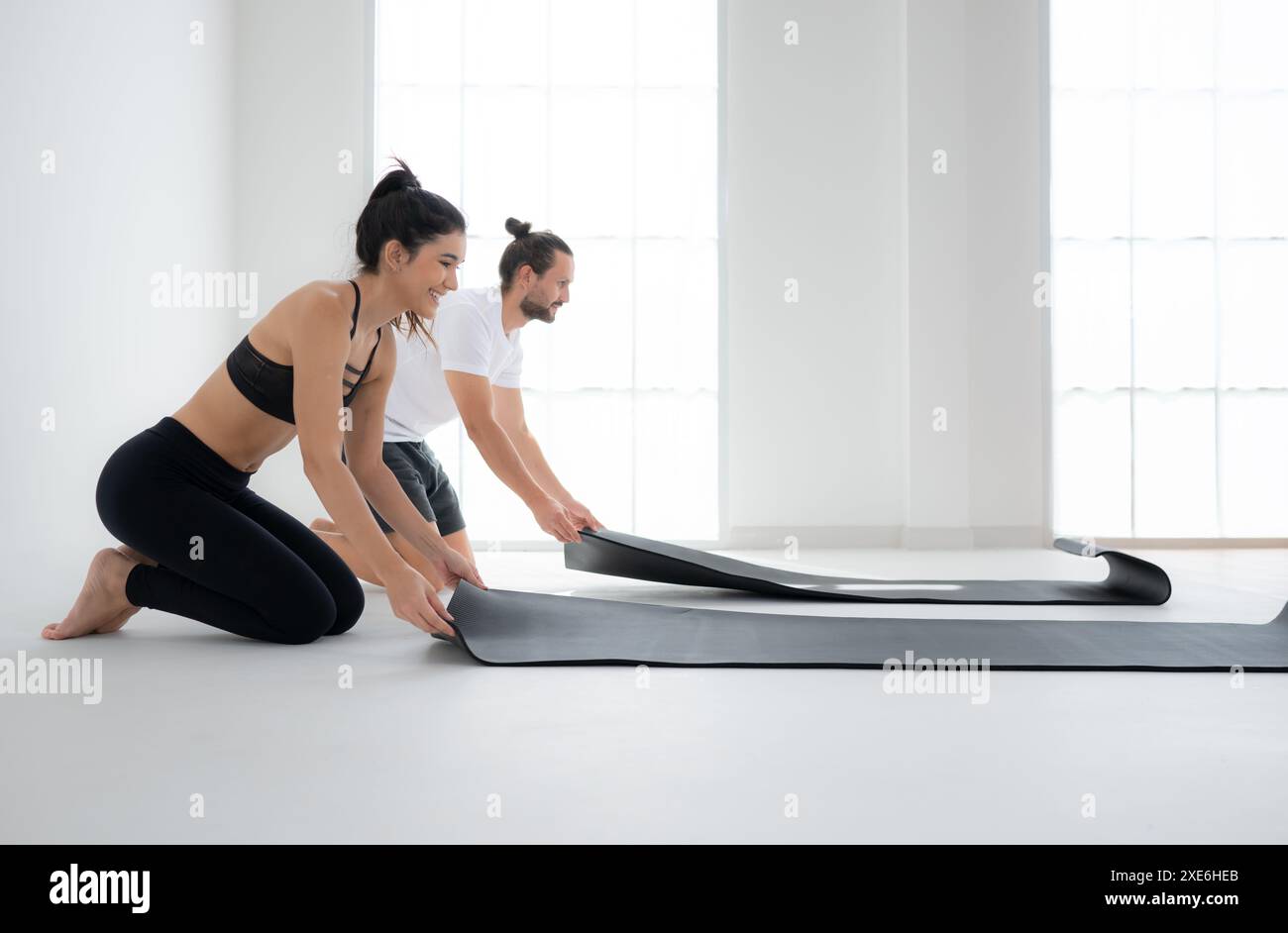 Couple doing yoga activities at home, Rolling up the yoga mat Stock ...