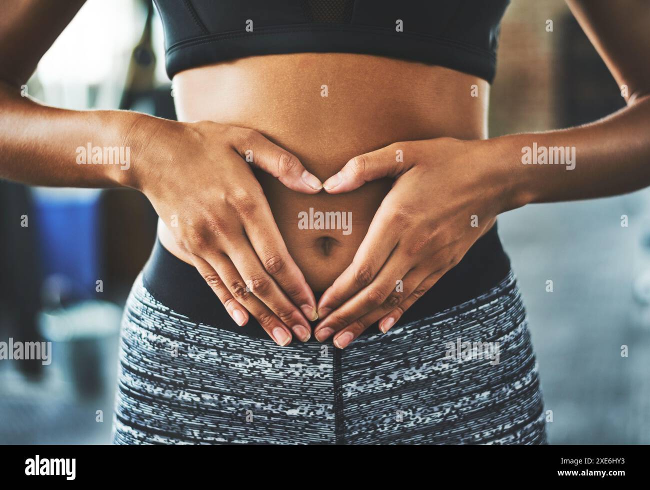 Health, digestion and hands on stomach for woman in gym, nutrition and ...