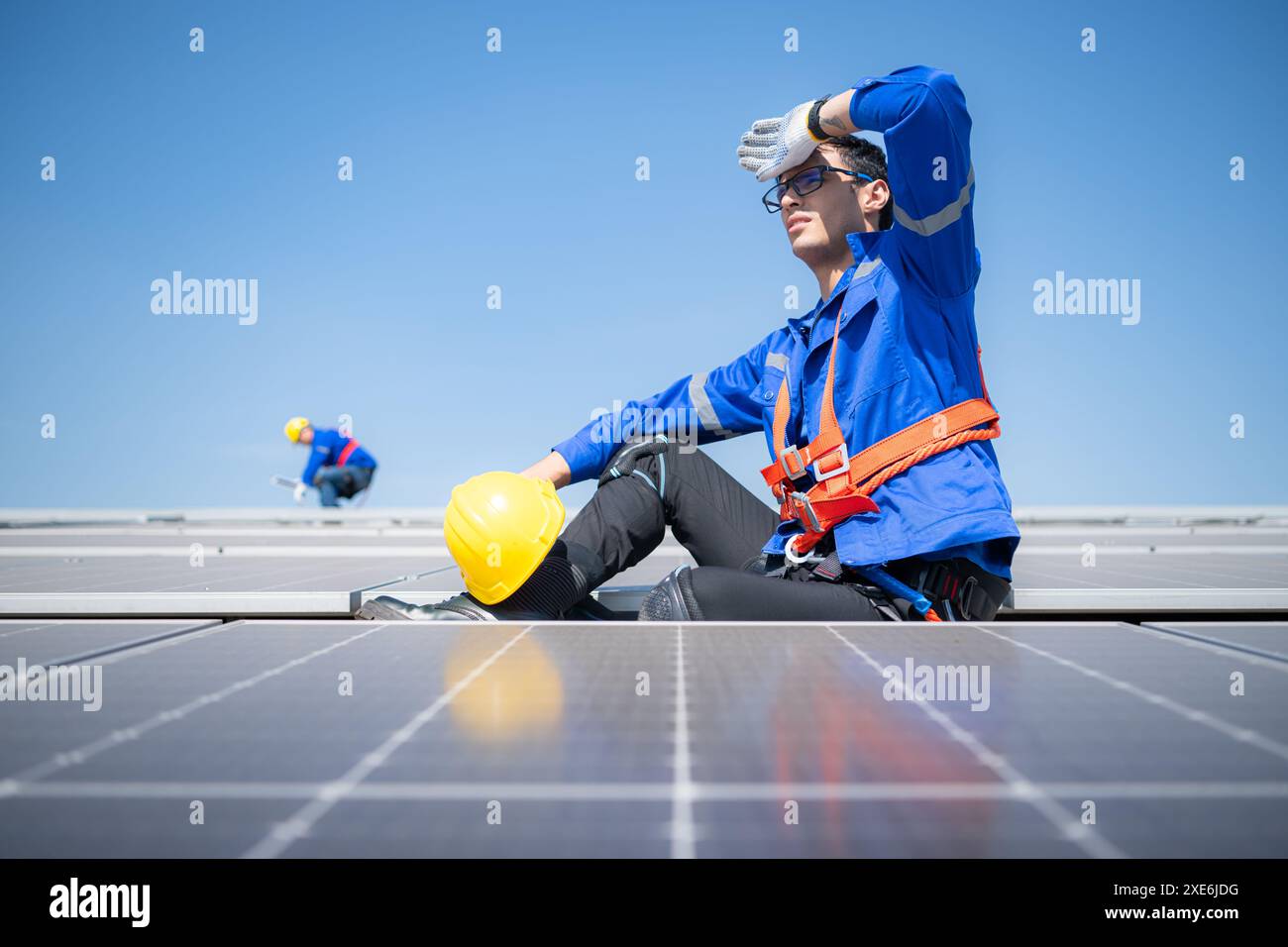 Technician repairing solar panels take off his hat and rest in the ...