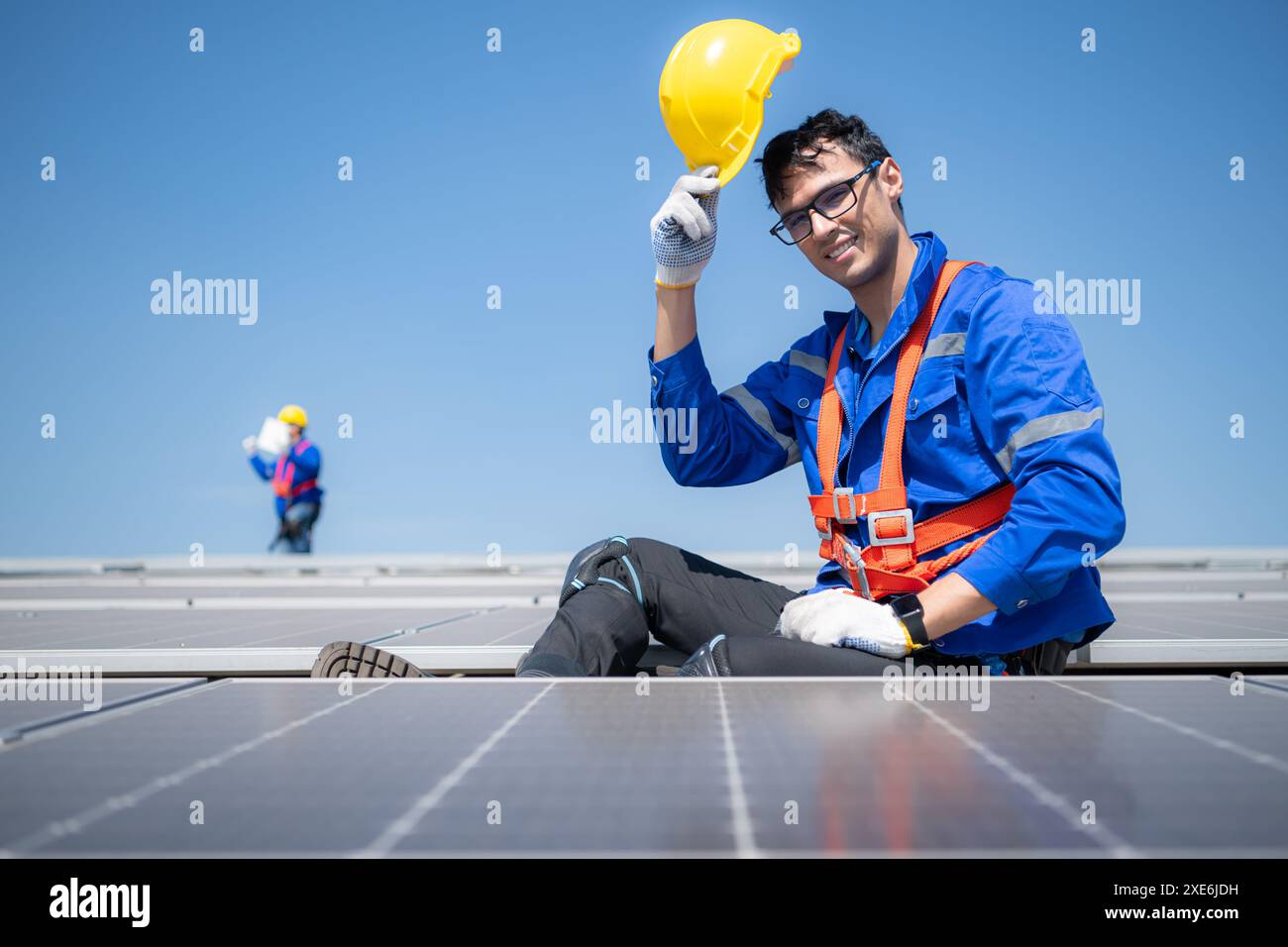 Technician repairing solar panels take off his hat and rest in the ...