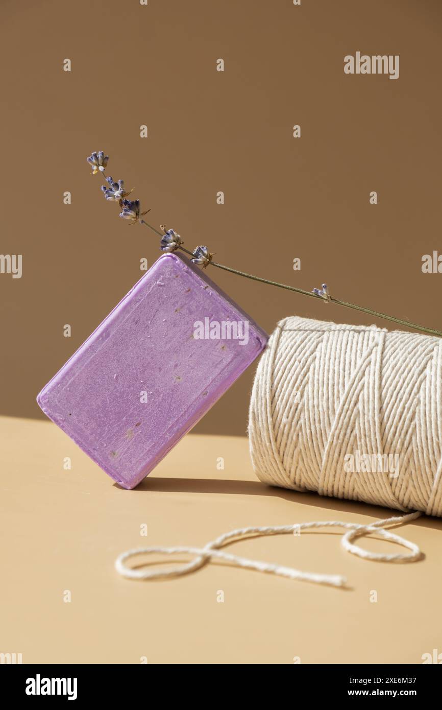 Lavender soap on beige background with spool of white cotton rope copy space for your text ...