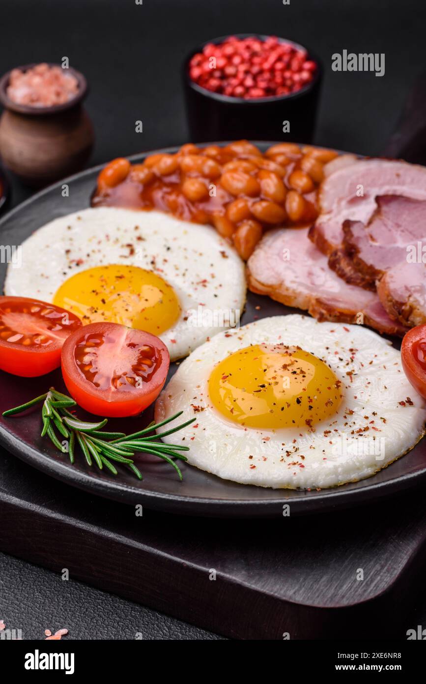 Delicious nutritious English breakfast with fried eggs and tomatoes ...