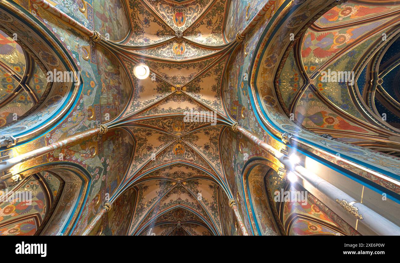 Ornate ceiling with religious art illuminating Basilica of Sts Peter ...