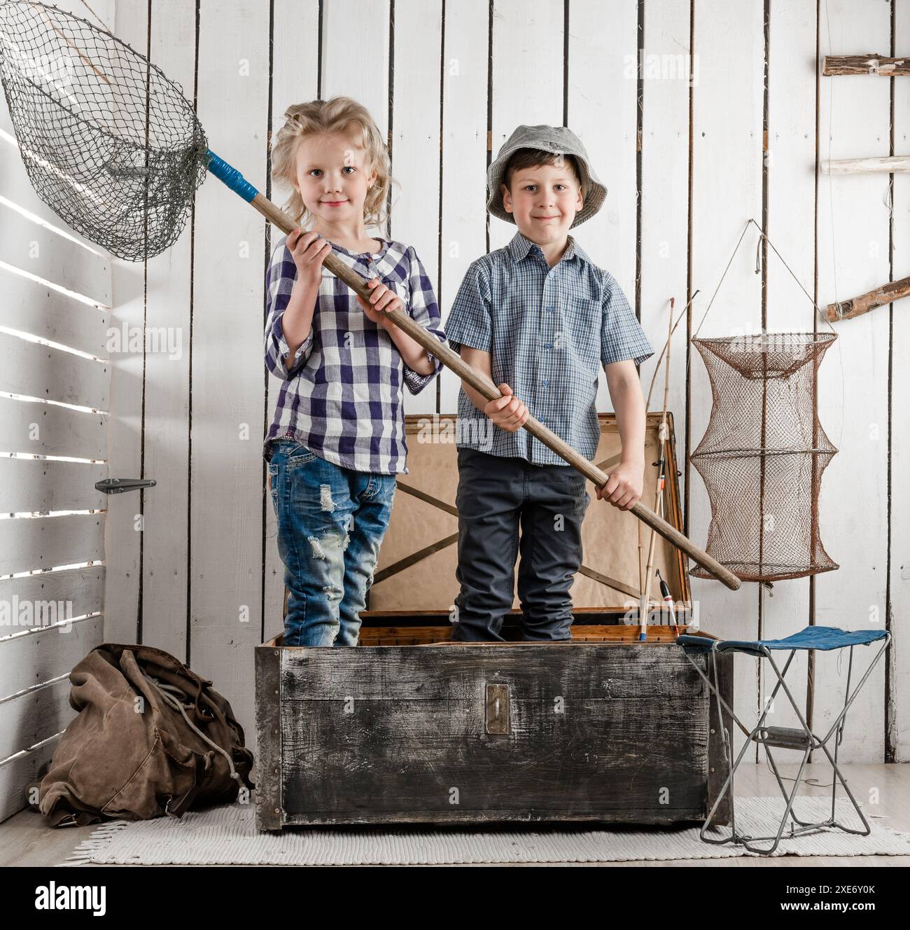 two cute little children standing in opened chest with net in hands ...