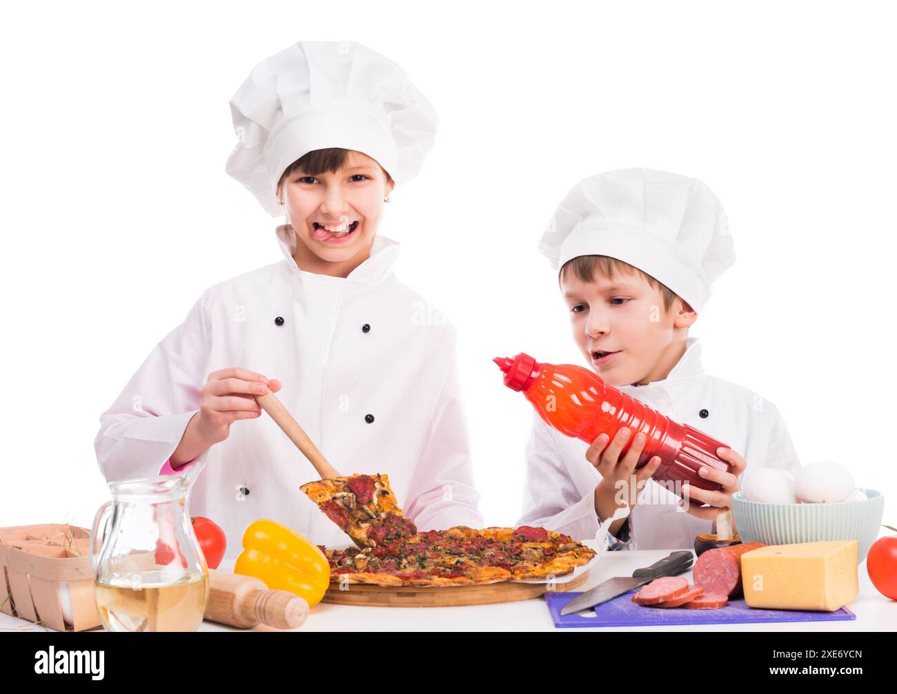 two smiling little cooks portioning fresh cooked pizza Stock Photo - Alamy
