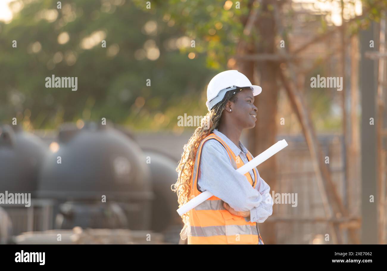 At the building site, a female engineer holds a blueprint in hand Stock ...